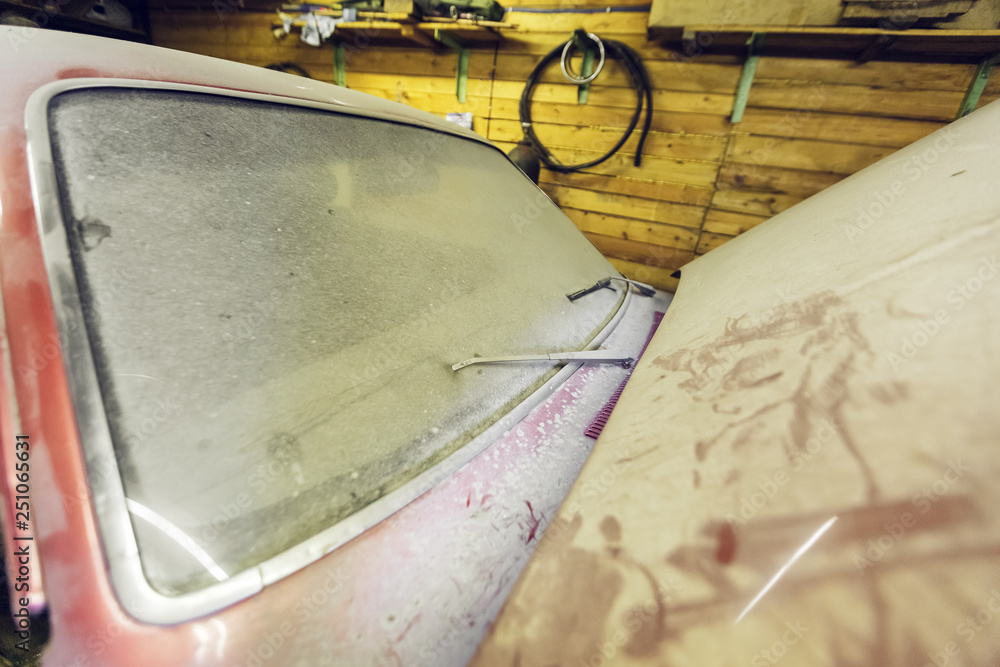 View of old car in garage with dusty hood dirty wind screen and broken ...
