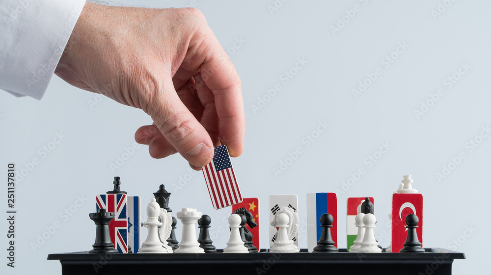 Politician's hand moves a chess piece with a flag. Conceptual photo of ...