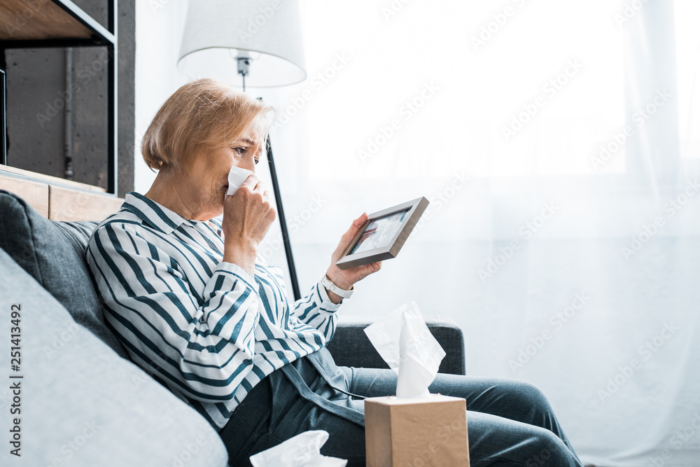 depressed senior woman crying and wiping face from tears with tissue ...