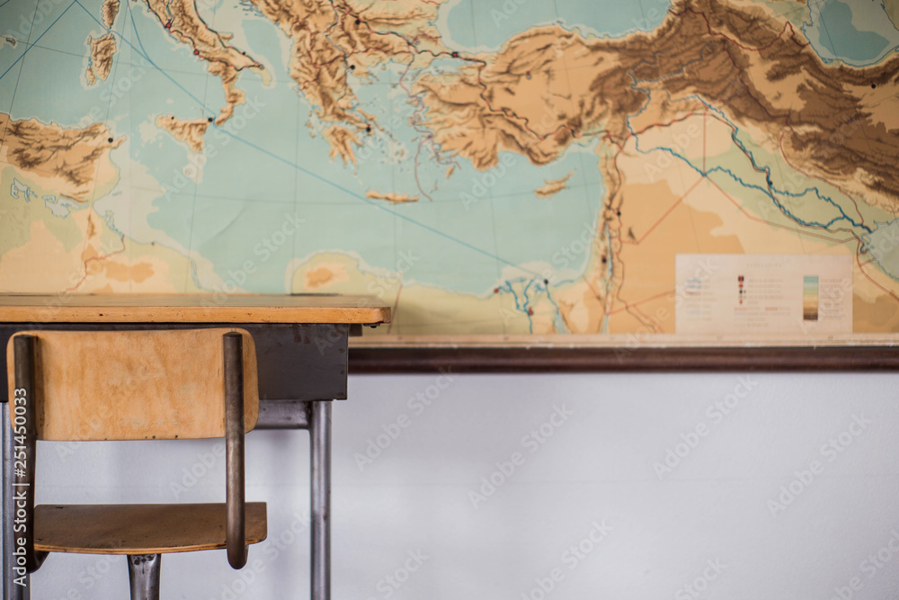 Empty desks at school classroom with world map. Stock Photo | Adobe Stock