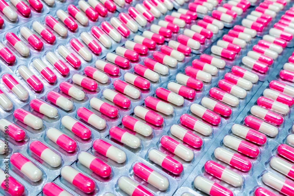 Pink-white antibiotic capsule pills in blister pack. Antibiotics drug ...
