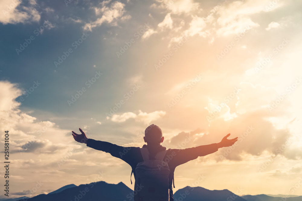 Backpacker man raise hand up on top of mountain with sunset sky and ...
