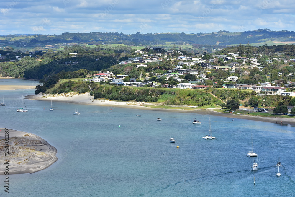 View of Mangawhai Harbour with moorings and sand dunes and dense ...