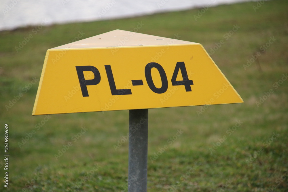 Yellow triangle warning signs above underground pipeline with tag ...