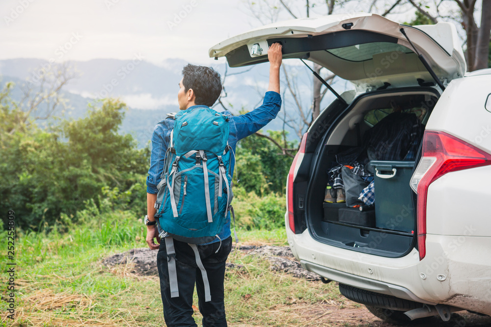 Man traveler driving car on to the mountains. Traveler with backpack ...