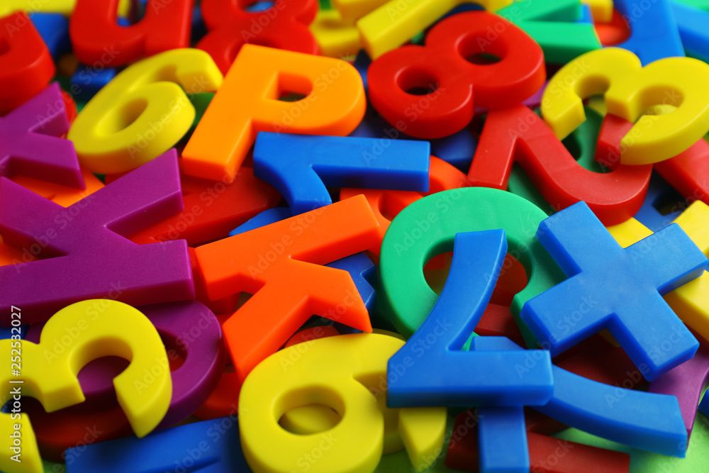 Colorful plastic magnetic letters and numbers as background, closeup ...