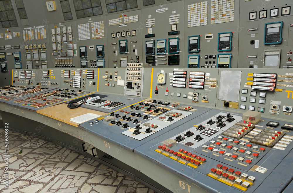 Operator sits in front of the main control board in a control ...