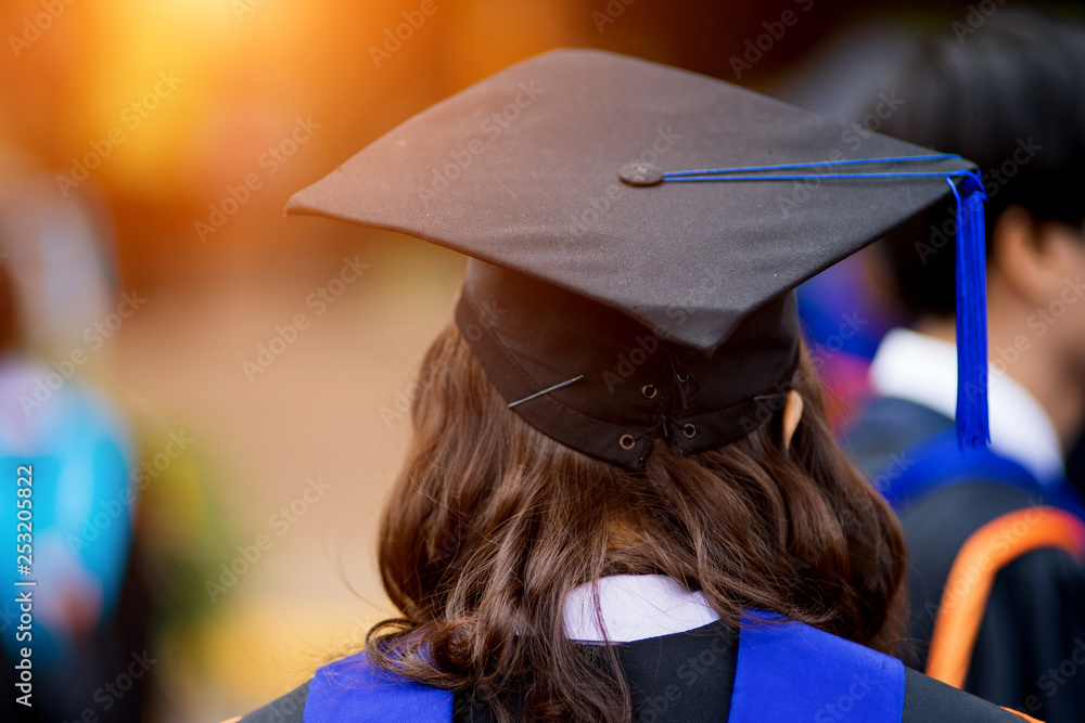 Rear view selective focus of the university graduates crowded in the ...
