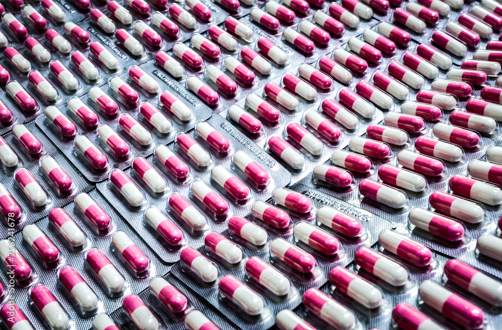 Pink-white antibiotic capsule pills in blister pack. Antibiotics drug ...