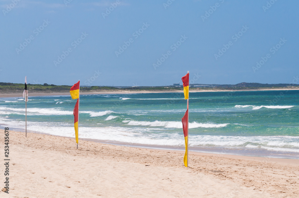 Foto de Stock Red and yellow flags on patrolled beach indicating safe ...