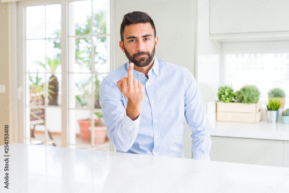 Handsome hispanic business man Showing middle finger, impolite and rude ...