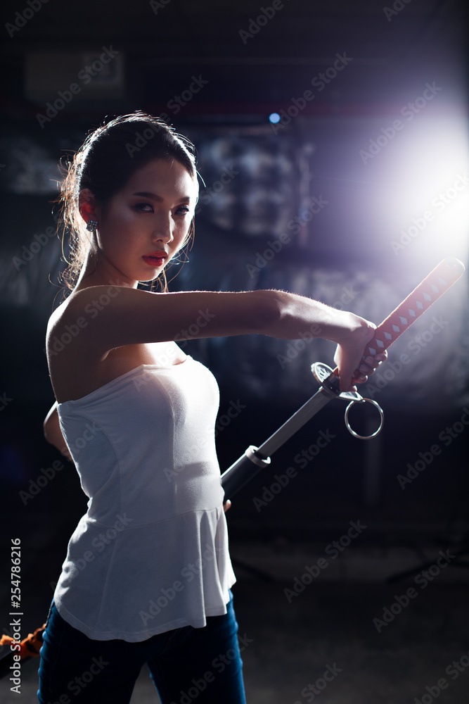 Beautiful Asian Woman demonstrates practice martial art Samurai blade ...