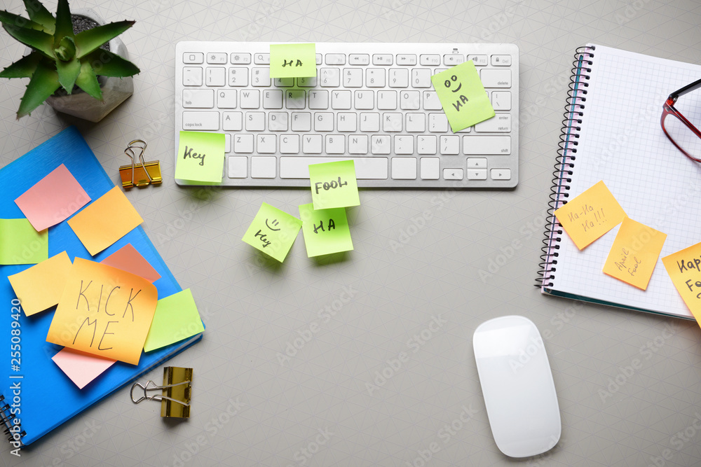 Computer keyboard with stationery and sticky notes on grey background ...