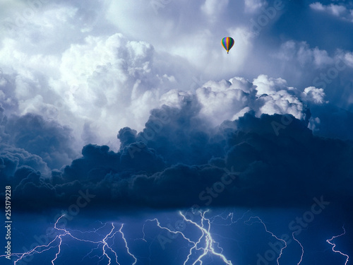 Hot air balloon floating near thunderstorm clouds with lightning Stock ...