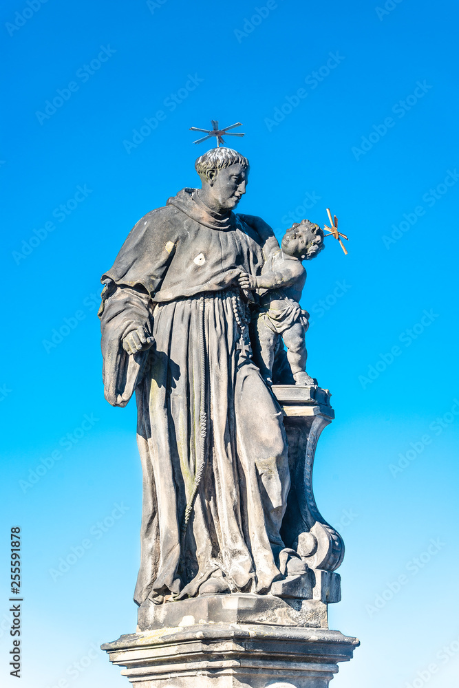 Statue of fat and big priest with a child at the Charles Bridge in ...