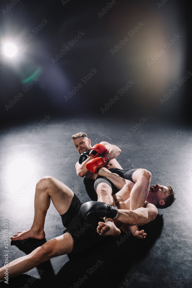 Strong shirtless mma fighter doing painful joint lock to another ...