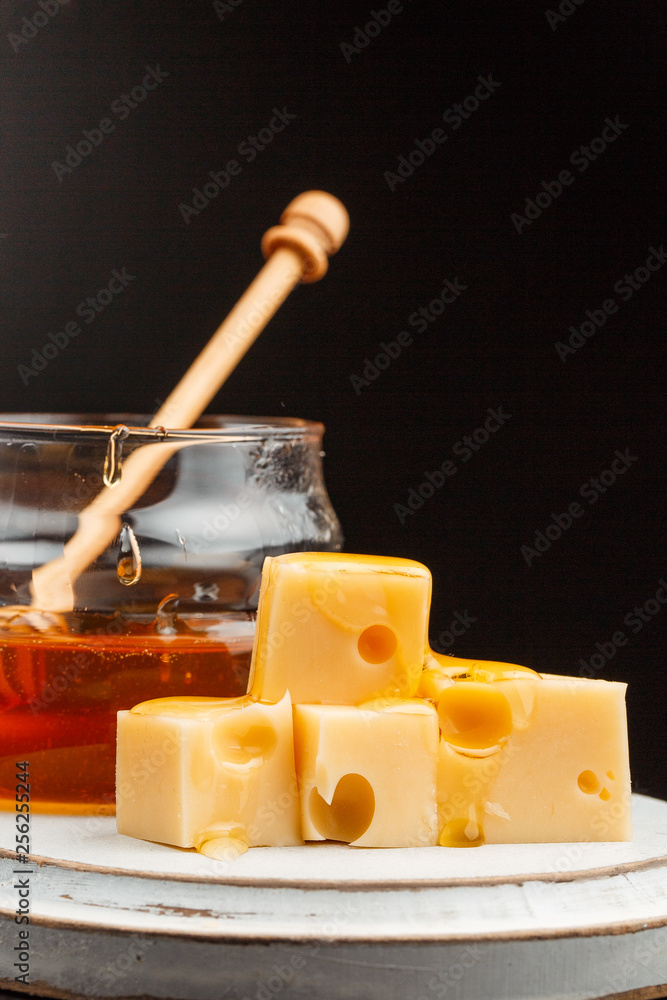 Slices of Swiss cheese pour honey on dark background . piece of tasty ...