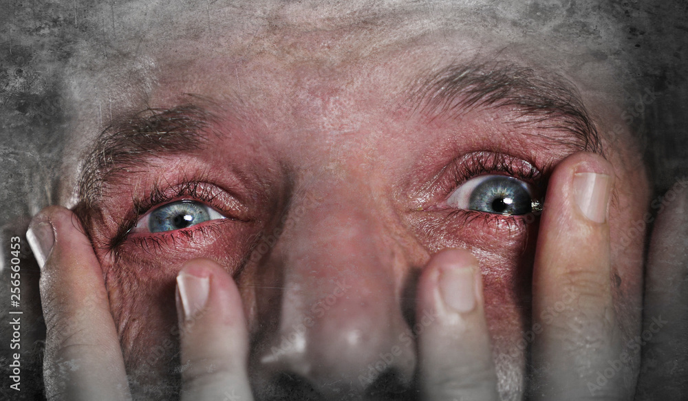young man with expressive eyes crying desperate in fear and horror ...