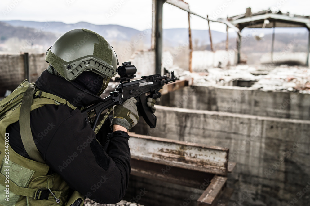 Foto de Stock Young Special forces SWAT soldier aiming with assault ...