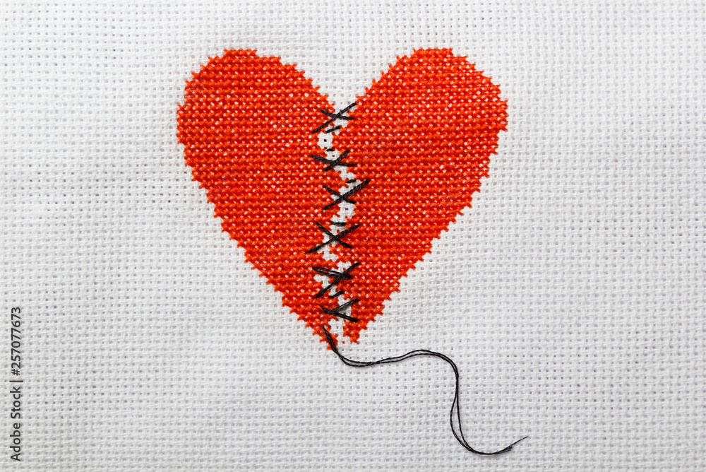 The broken red heart is threaded with black threads. Heart embroidered ...