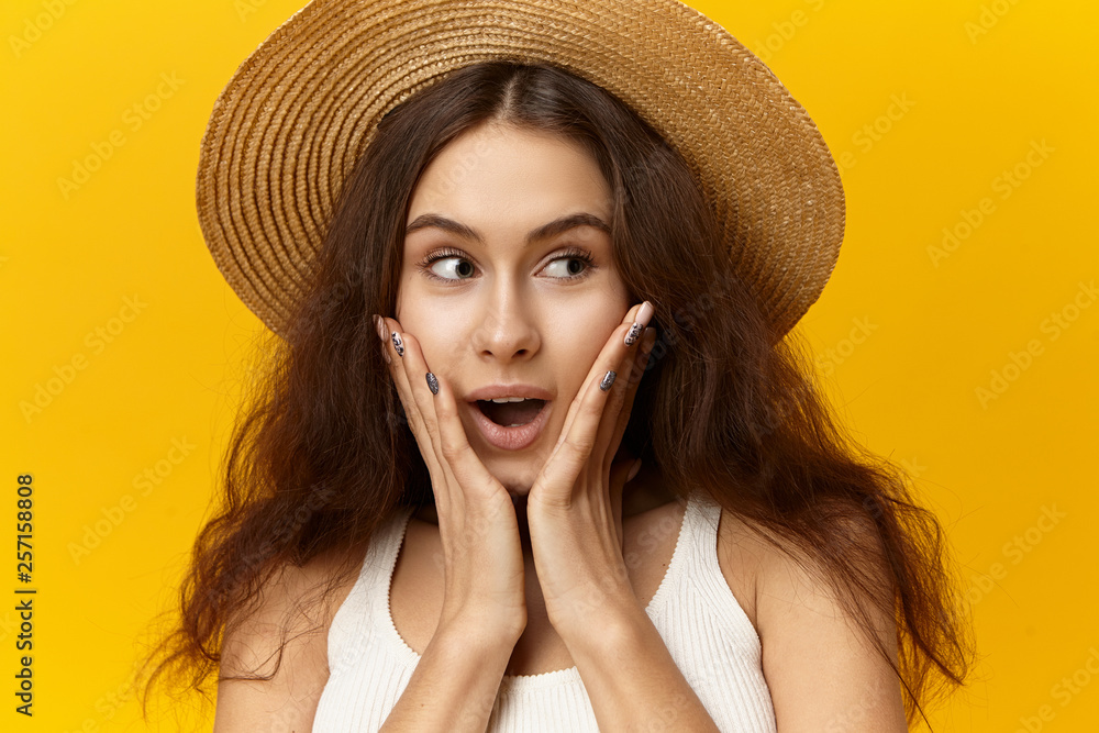 Positive fashionable slim European girl with bun loose wavy hair ...