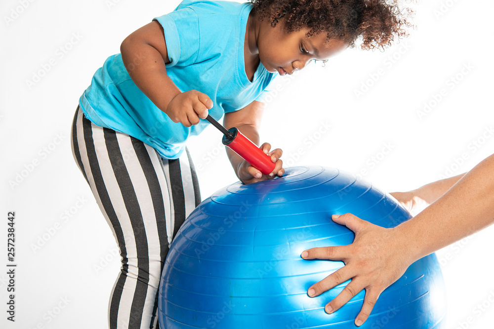 Little girl curly hair playing a big ball while Learn by yourself ...