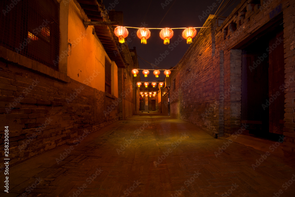 Red lanterns and bokeh at night in a street in Pingyao. The ancient ...