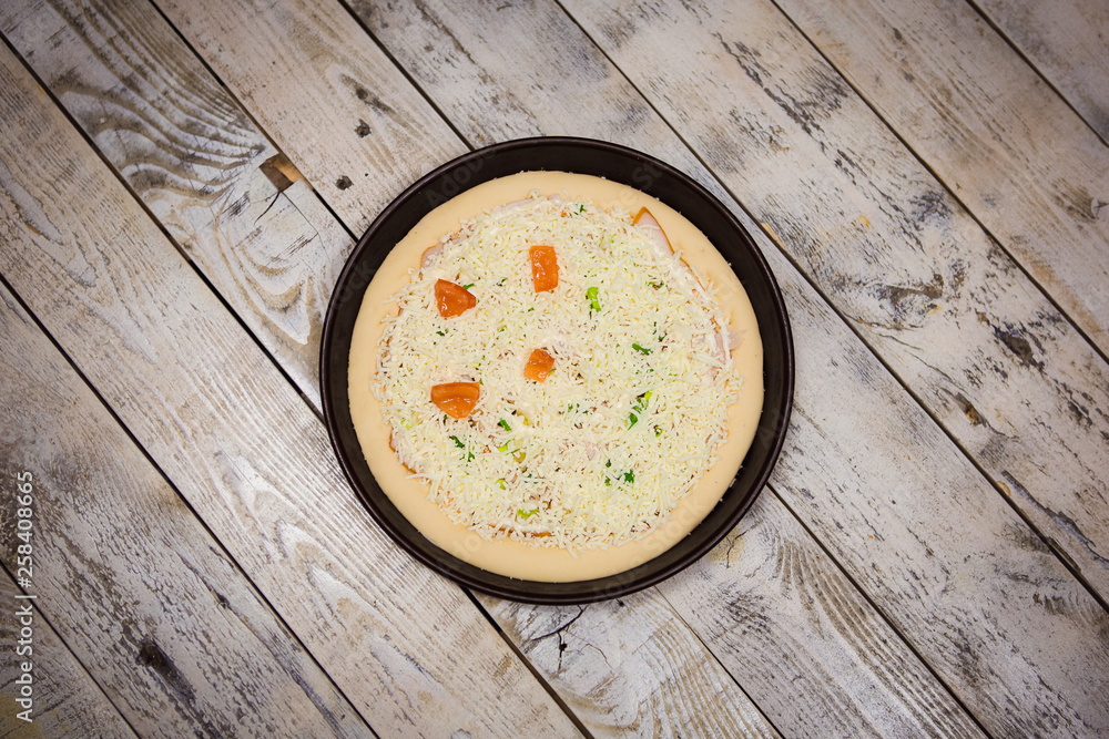 Round pizza dough is in the pan. The process of cooking pizza, stacking ...