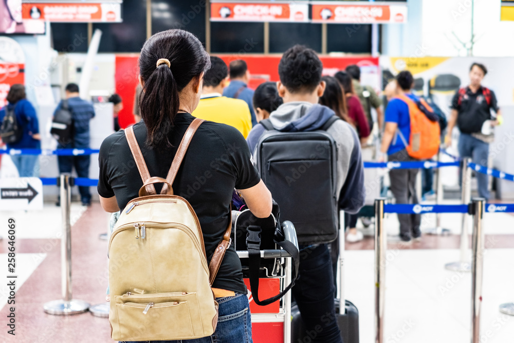 Young Thai woman standing in queue waiting to check-in registration ...