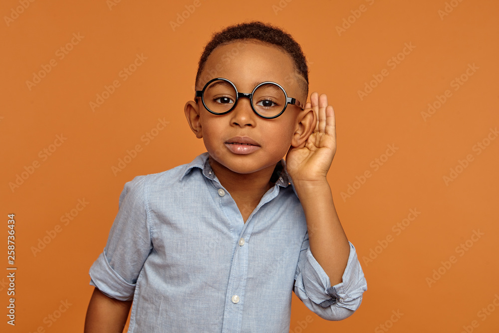 Studio shot of stylish curious snoopy Afro American schoolboy in trendy ...