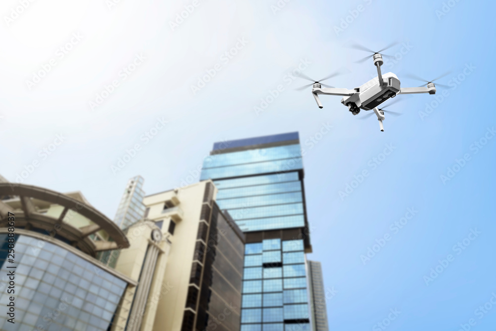 White drone with camera flying to the top of modern building Stock ...