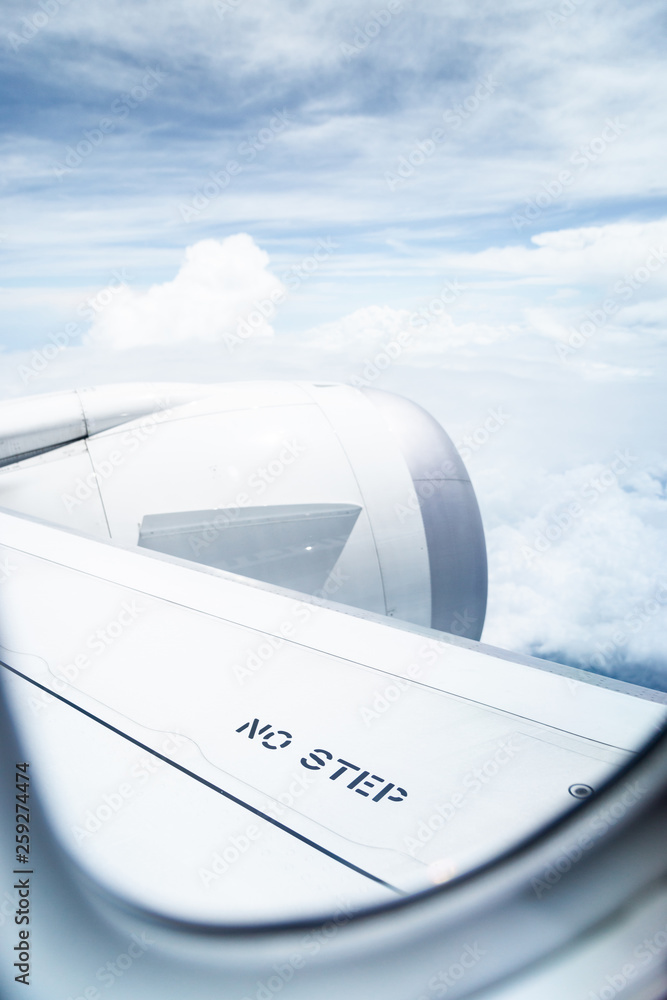 No step sign on commercial airplane wing, airplane in flight, shot ...