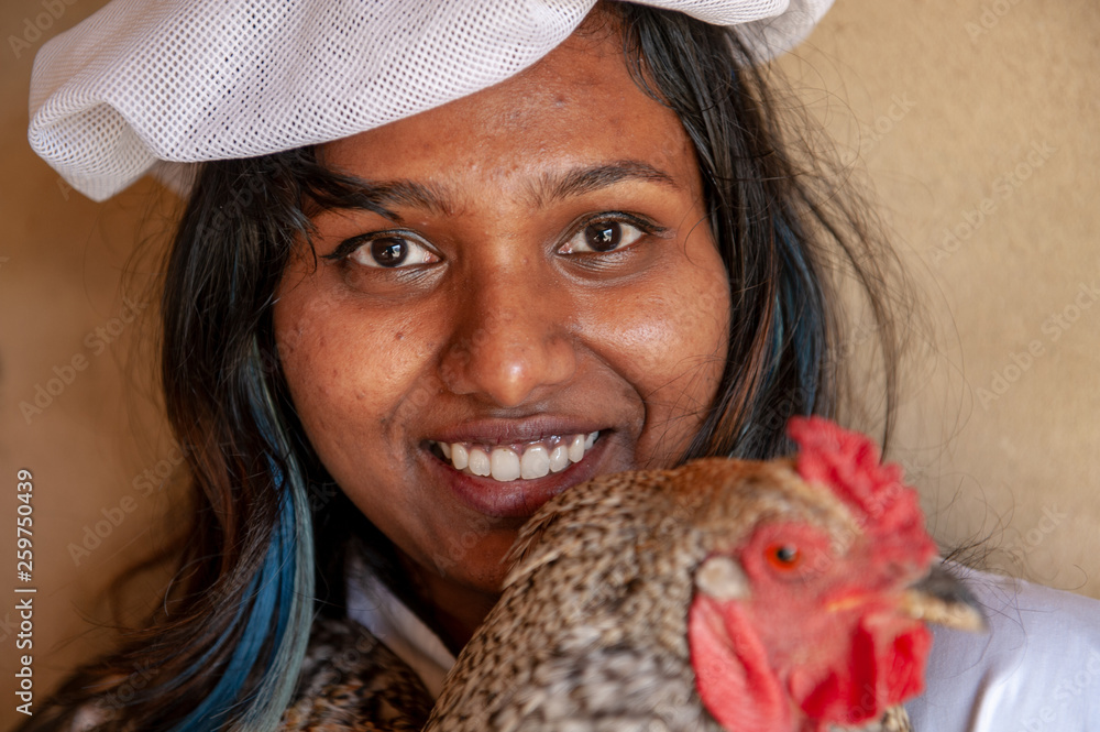 Attractive Indian woman cook posing in kitchen with chicken in her ...