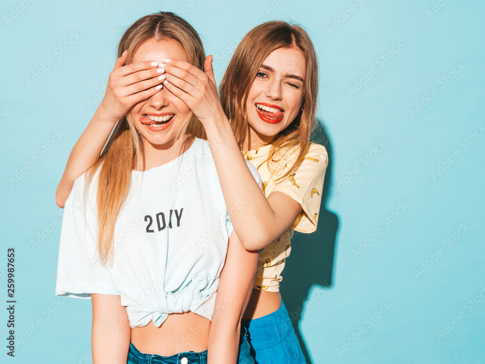 Girl surprising her female best friend. Model covering her eyes and ...