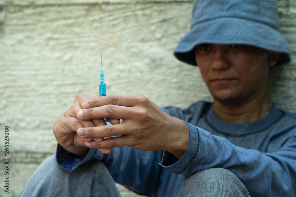close up of Syringe and Needle in hand of drug addict man. homeless ...