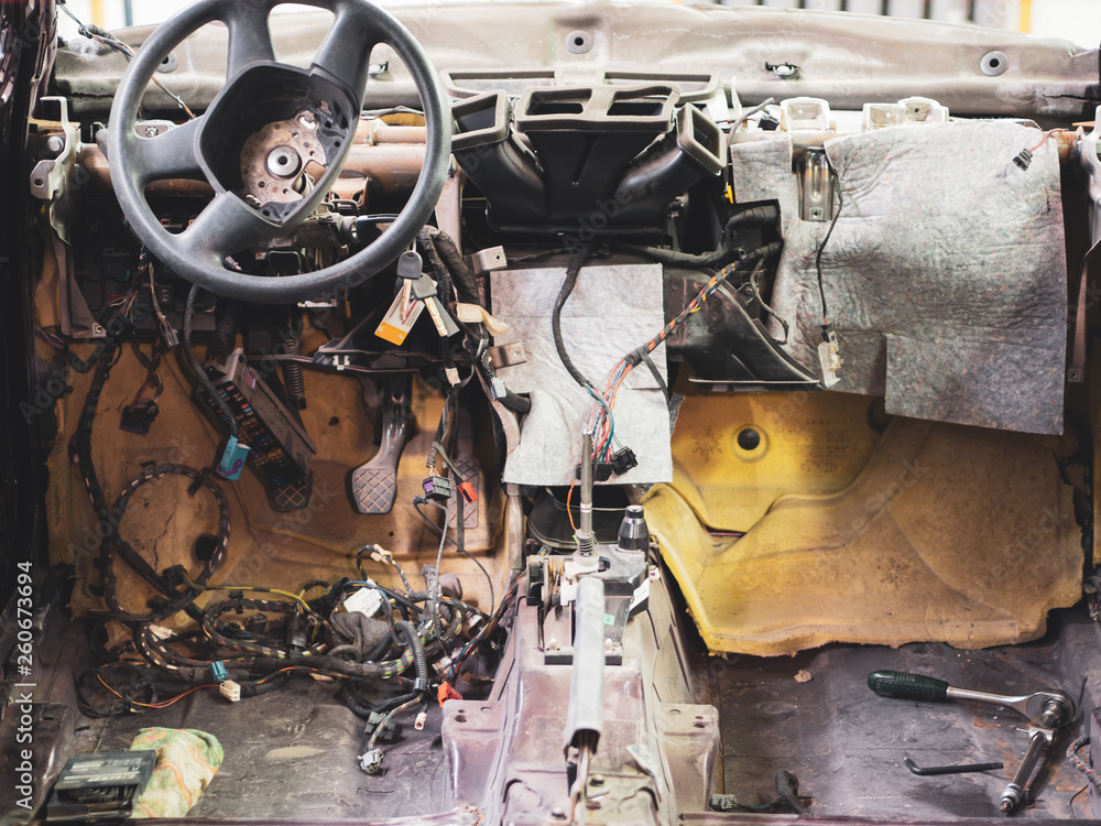 Disassembled console in car with lots of colorful wires; many vehicles ...