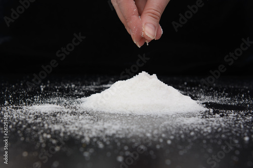 in the fingers of a young woman a pinch of salt, which she pours down ...