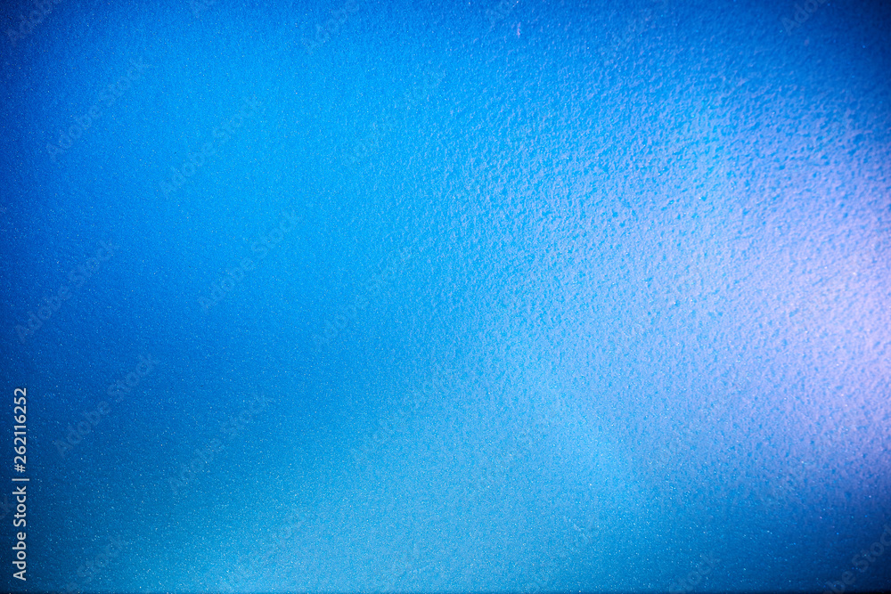 Uniform textural blue background with partial blur and light pink glow ...