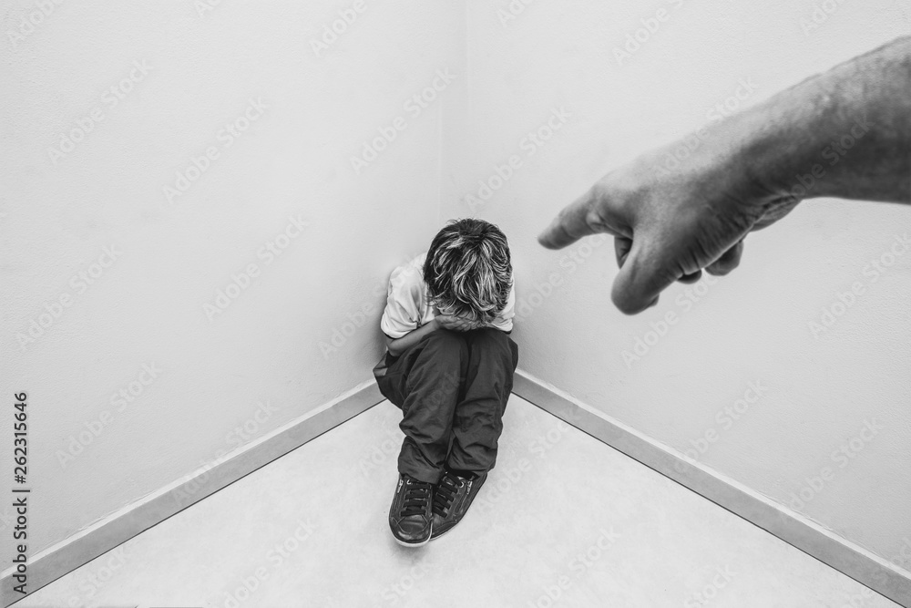 Adult hand pointing at child in school uniform crying, concept of child ...