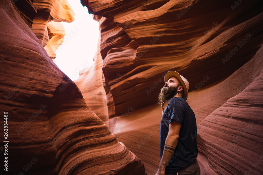 Side view of bearded male examining amazing walls of wonderful ravine ...