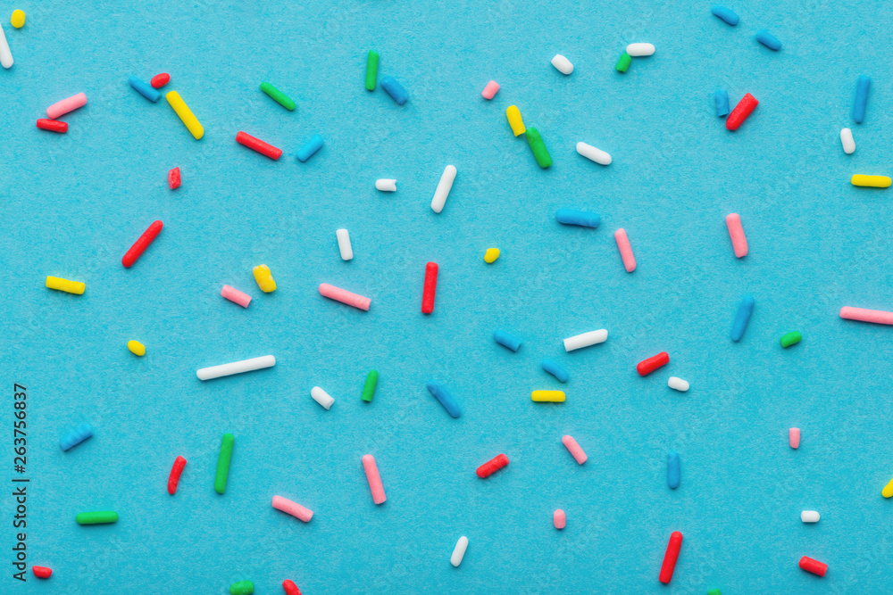 top down of colorful sprinkles over blue background, festive decoration ...