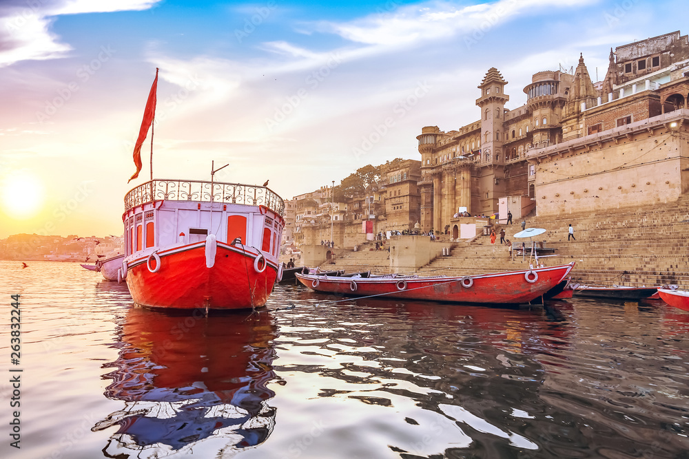 Varanasi city with ancient architecture buildings and wooden boats ...