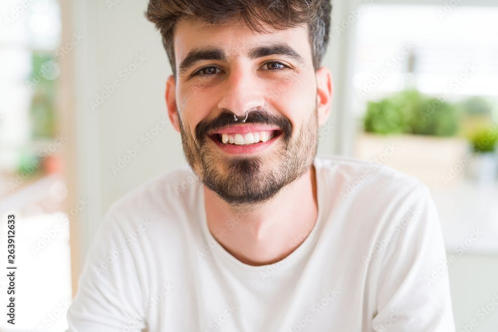 Photo Stock Handsome young man smiling cheerful at the camera with a ...