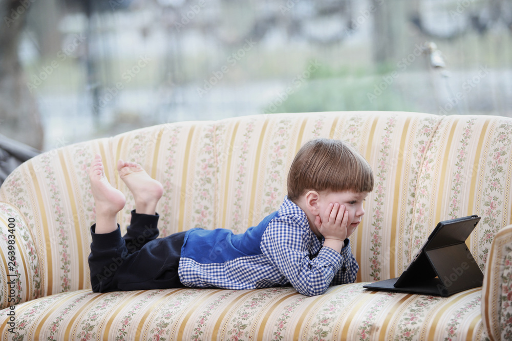 Ein kleiner Junge bedient ein ipad Stock Photo | Adobe Stock
