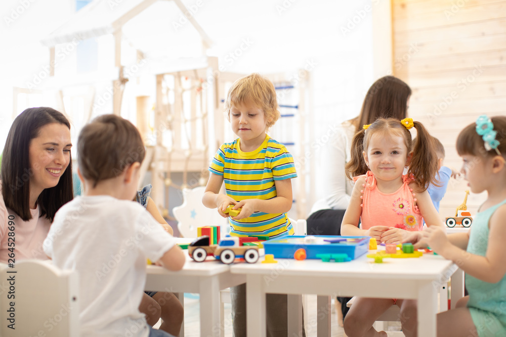 Group of kids playing together in the classroom in kindergarten or ...