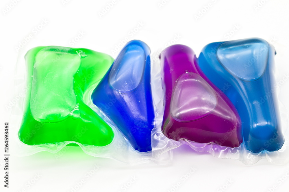Two different kinds of laundry detergent pods, blue/green and purple ...