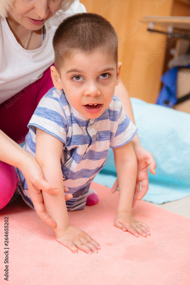 little kid with cerebral palsy has musculoskeletal therapy by doing ...