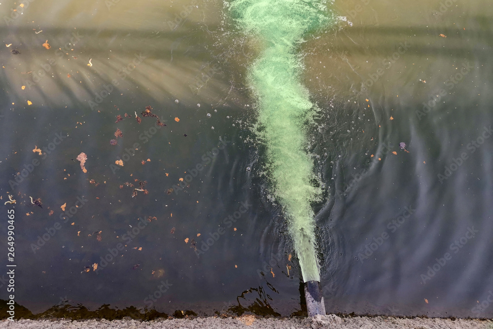 Dirty green chemical polluted water flows into the river, the lake, the ...