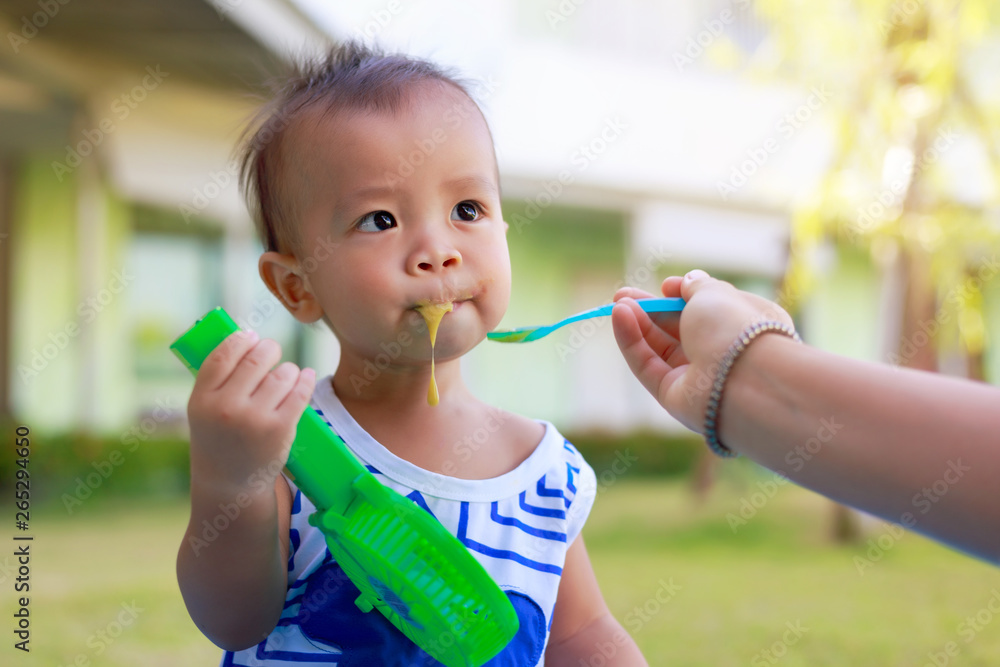 Asian baby boy is spit out for foods that the mother feeds. family ...