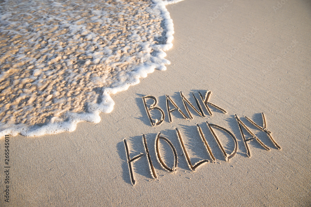 Bank Holiday message handwritten on the textured sand of an empty beach ...